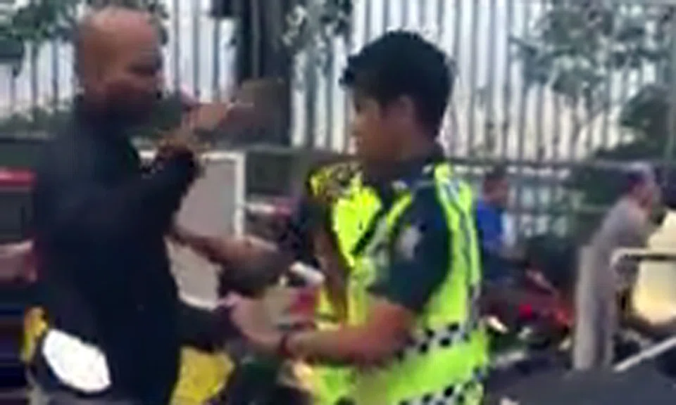 Biker argues with enforcement officer at checkpoint, while other bikers ...