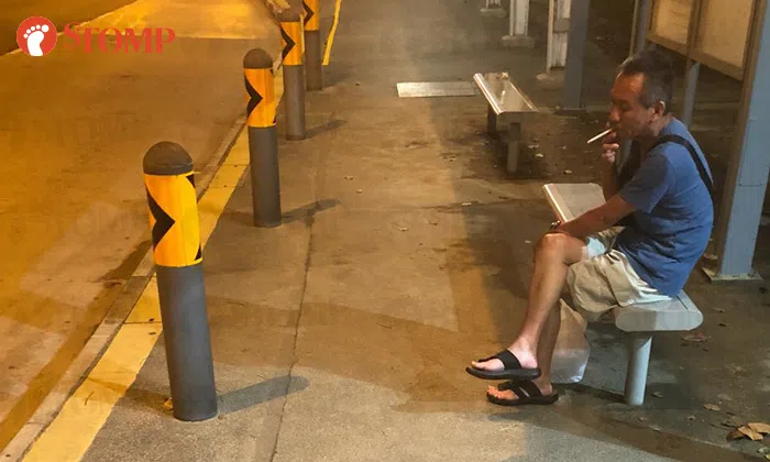 Uncle smokes at Soo Teck station bus stop, casually throws cigarette ...