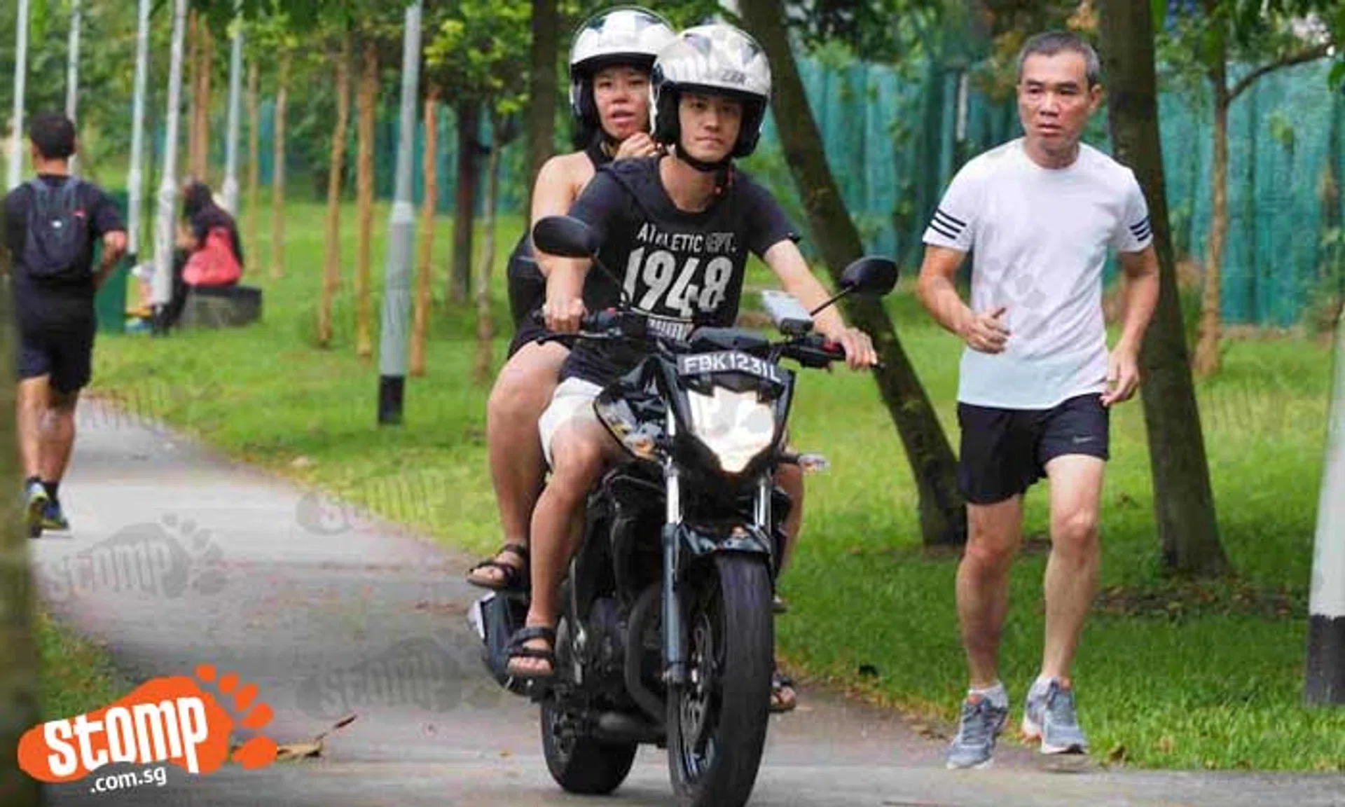 Motorcyclist squeezes past park-goers on jogging track at Bishan Park ...