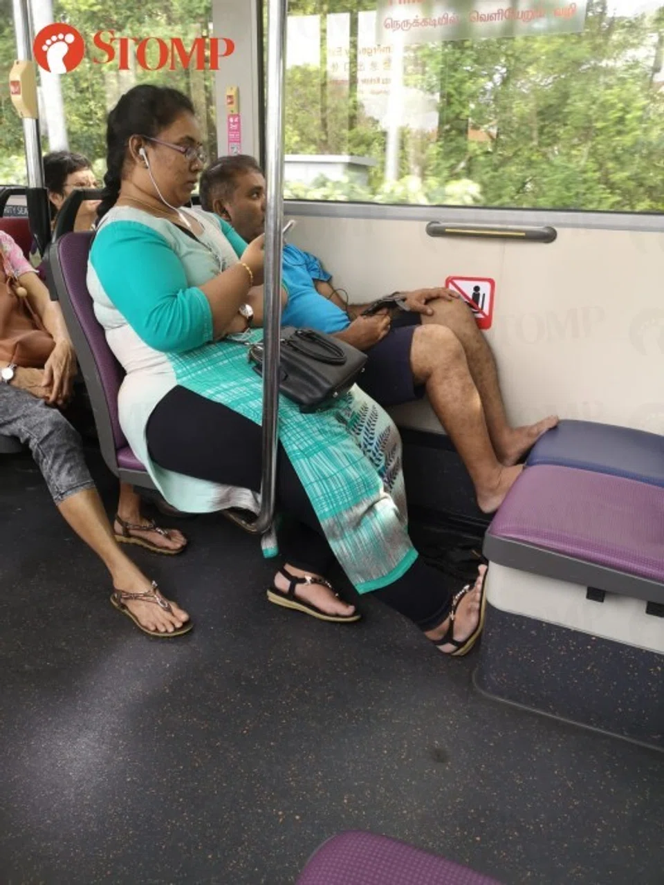Commuter puts legs on seat while sitting beside sign that disallows ...