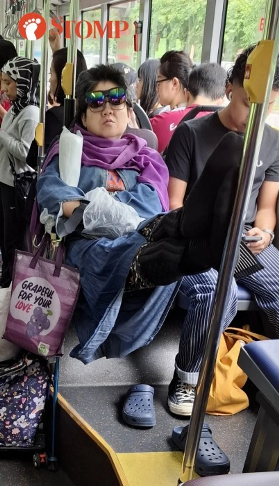 Woman continues to sit like a queen with both legs propped up on bus ...