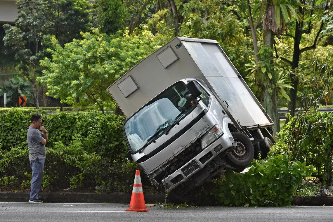 Lorry left balancing on two wheels on centre divider in Braddell Road ...